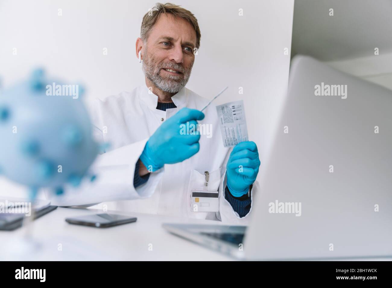 Scientist holding up lateral flow test device in video conference Stock ...