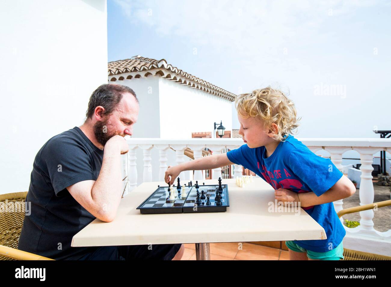 Father son playing chess on roof terrace hi-res stock photography and ...