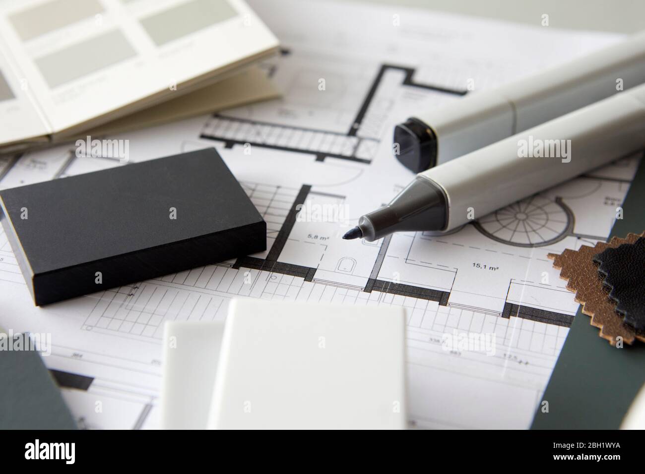 Felt tip pens and material swatches lying on architectural blueprint ...