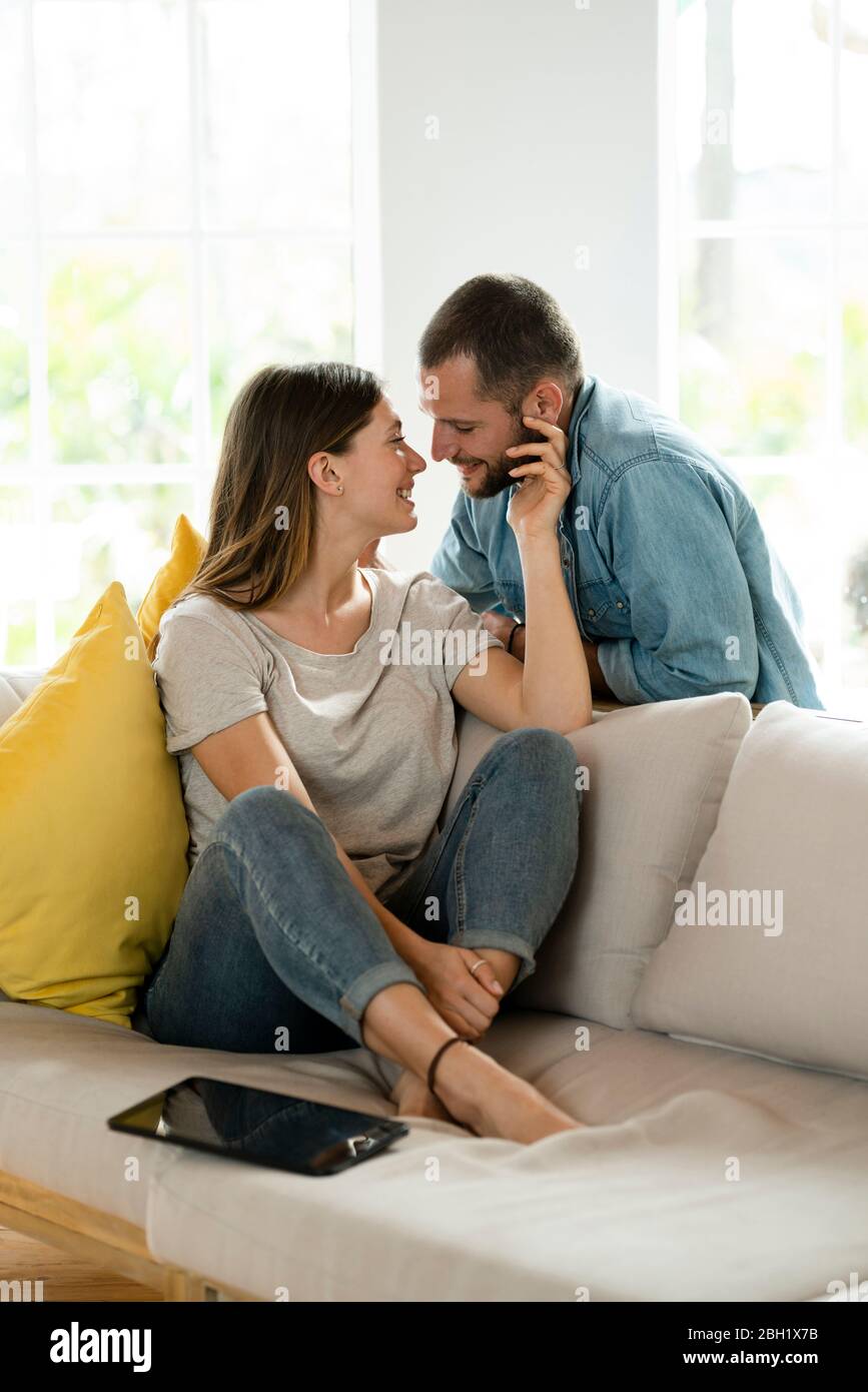 Affectionate couple in love about to kiss while relaxing at home on ...