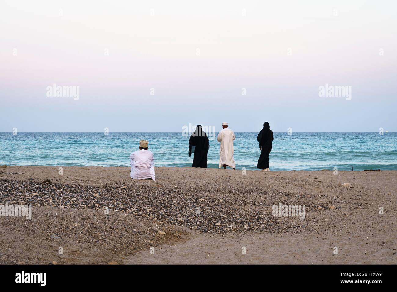 Omani men and woman in traditional dress on the beach, Qantab, Oman ...