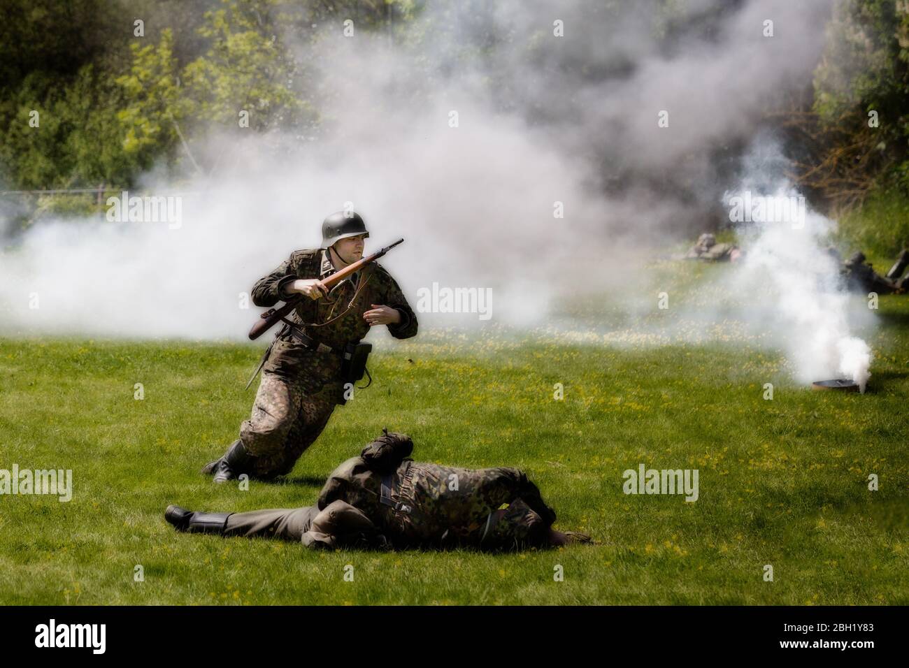 WW2 soldiers on the battlefield reenacting battle scenes with guns and ...