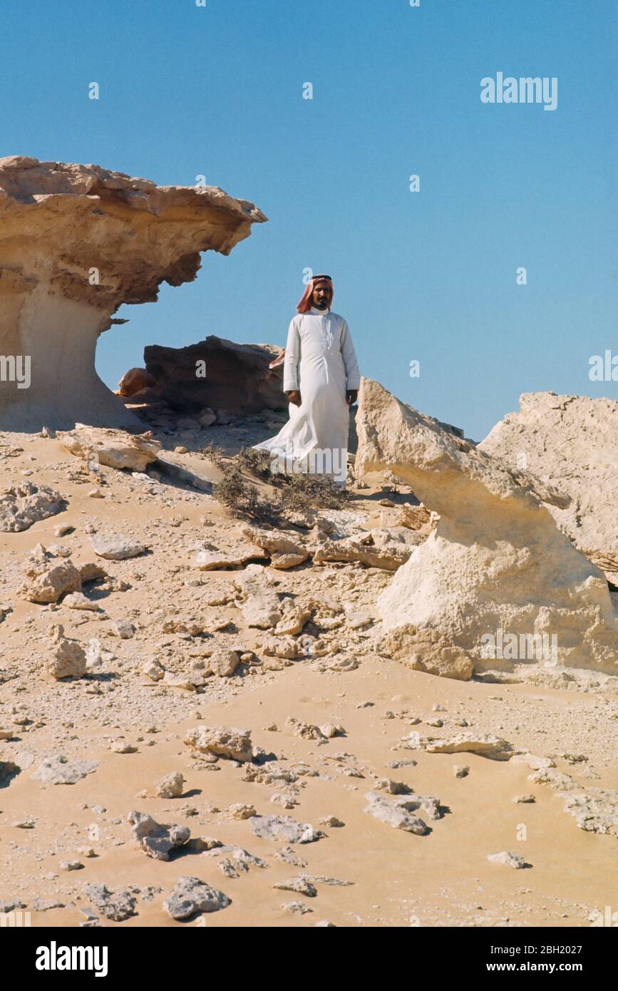 Qatar, Desert, Bedouin man stood on rocky landscape Stock Photo - Alamy