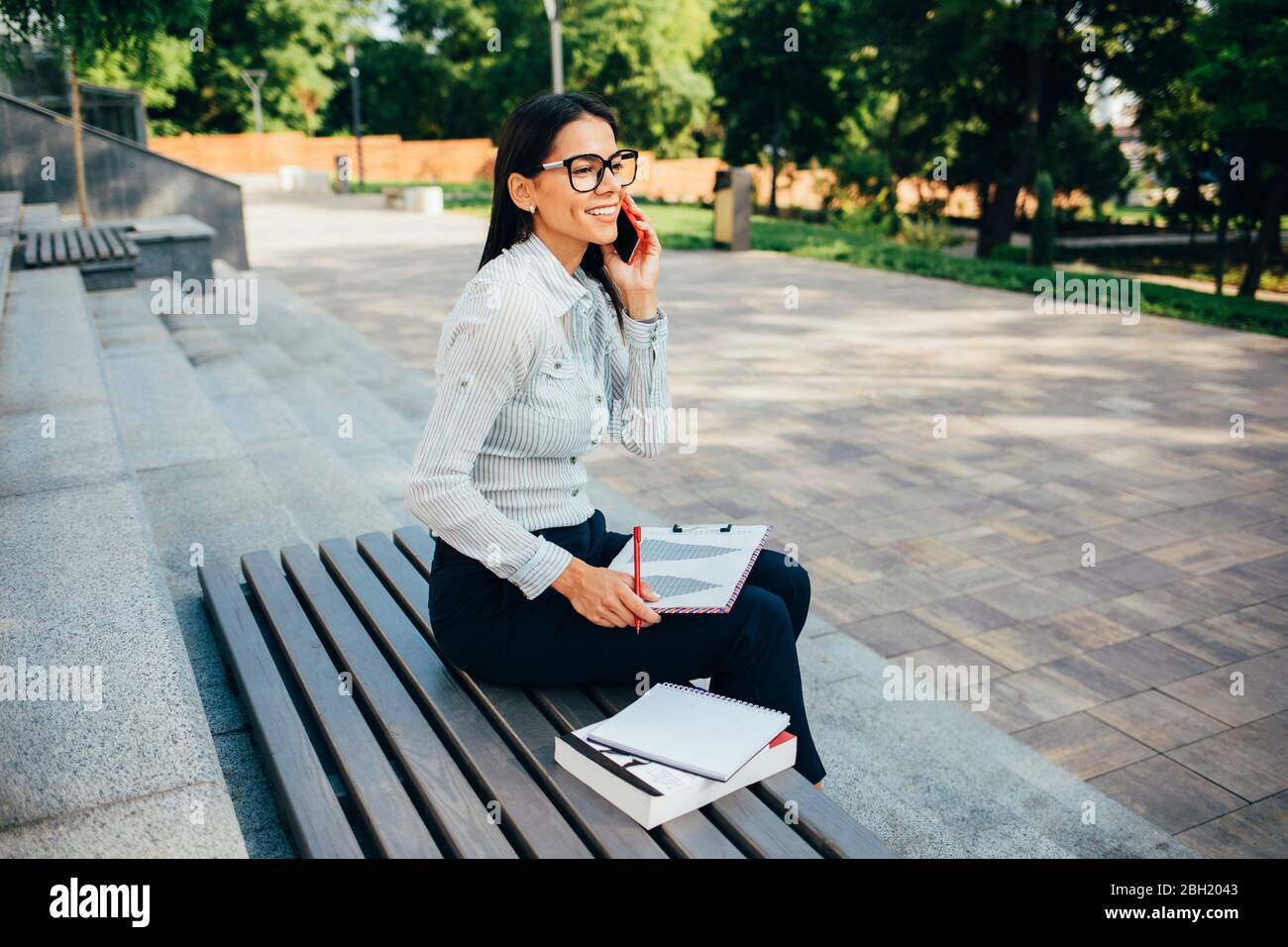 Three people sitting on a park bench hi-res stock photography and ...