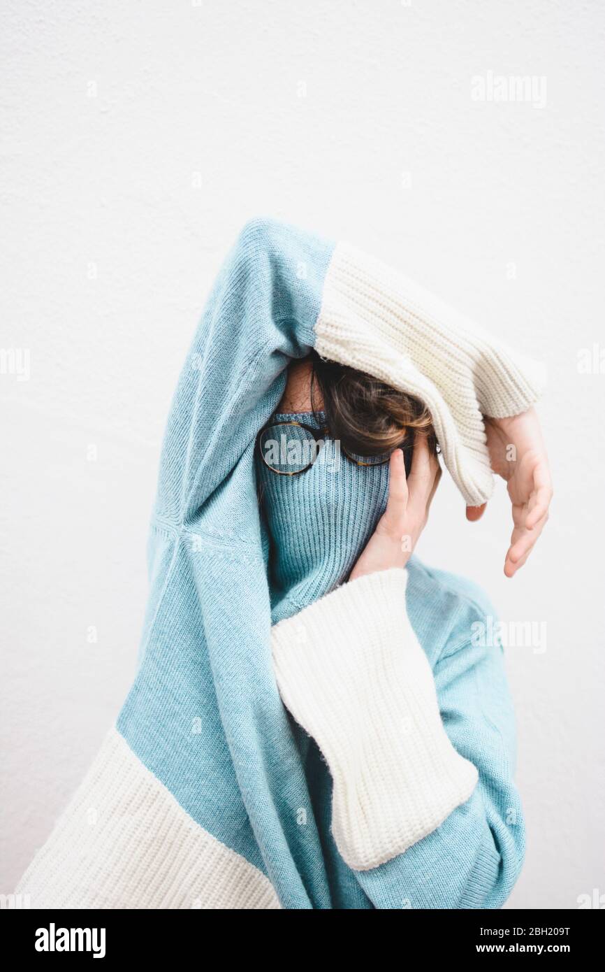 Young woman covering her face with turtle neck Stock Photo - Alamy