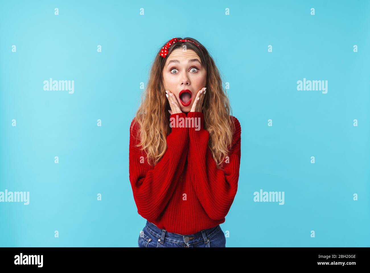 Image of a shocked young woman posing isolated over blue wall ...