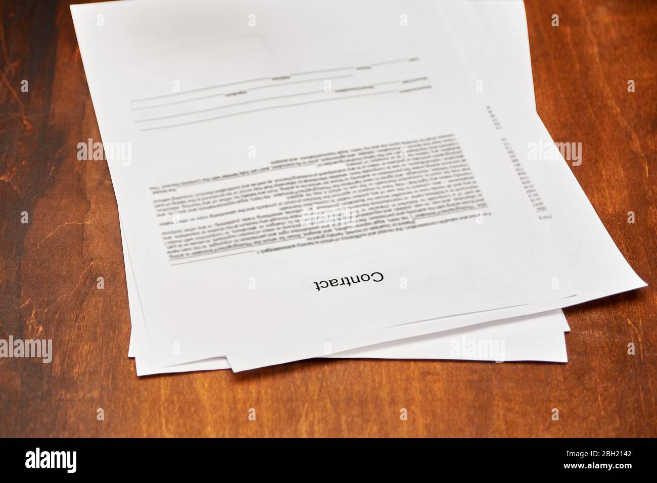 on a wooden table is a contract form Stock Photo - Alamy