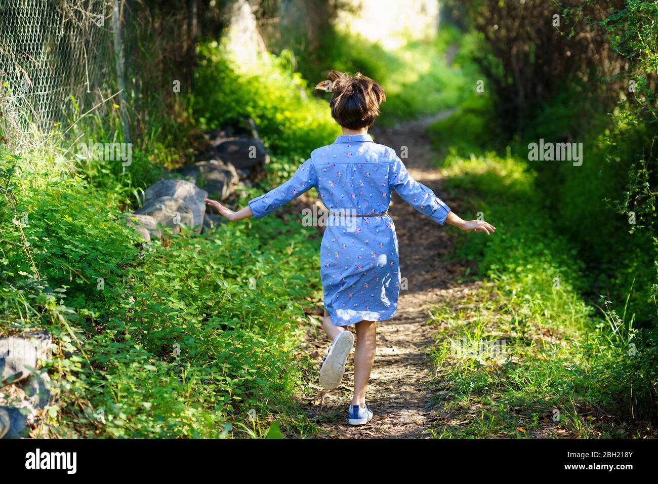 Girl running on a rural path, rear view Stock Photo - Alamy