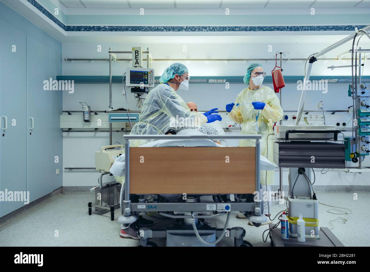 Doctors caring for patient in emergency care unit of a hospital taking ...