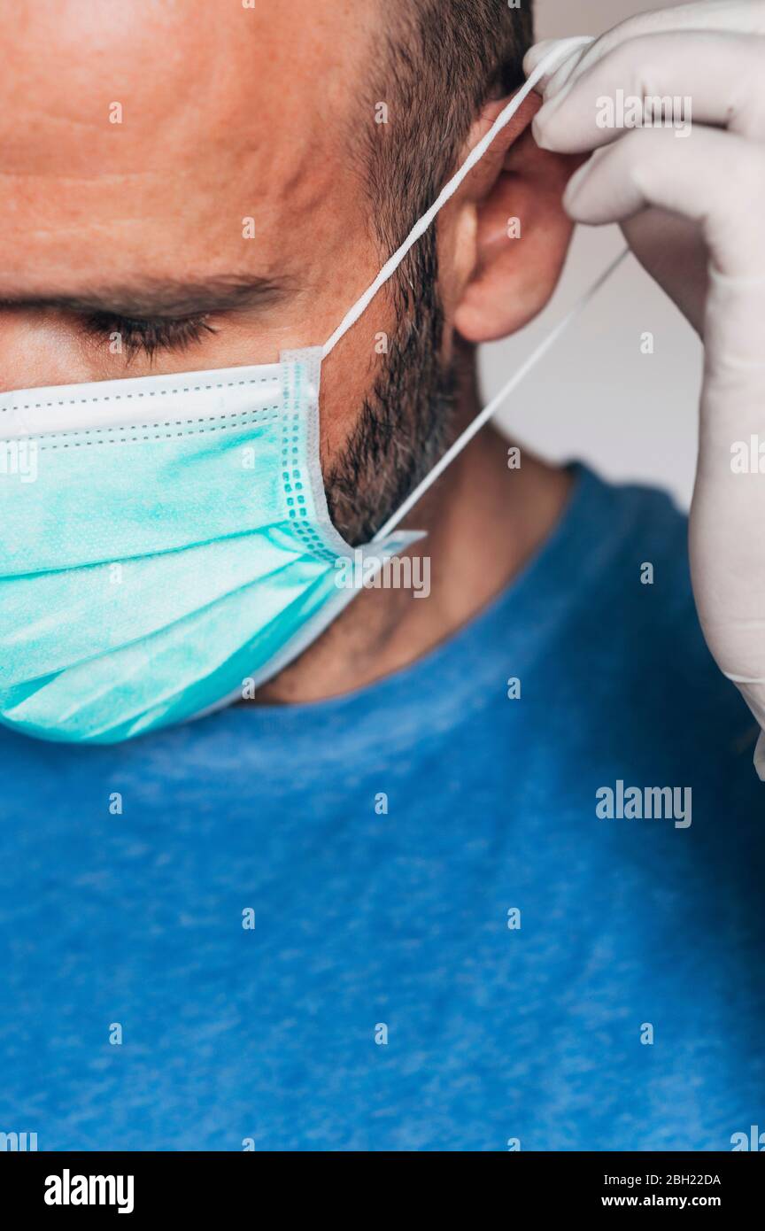 Portrait of man putting on mask Stock Photo - Alamy
