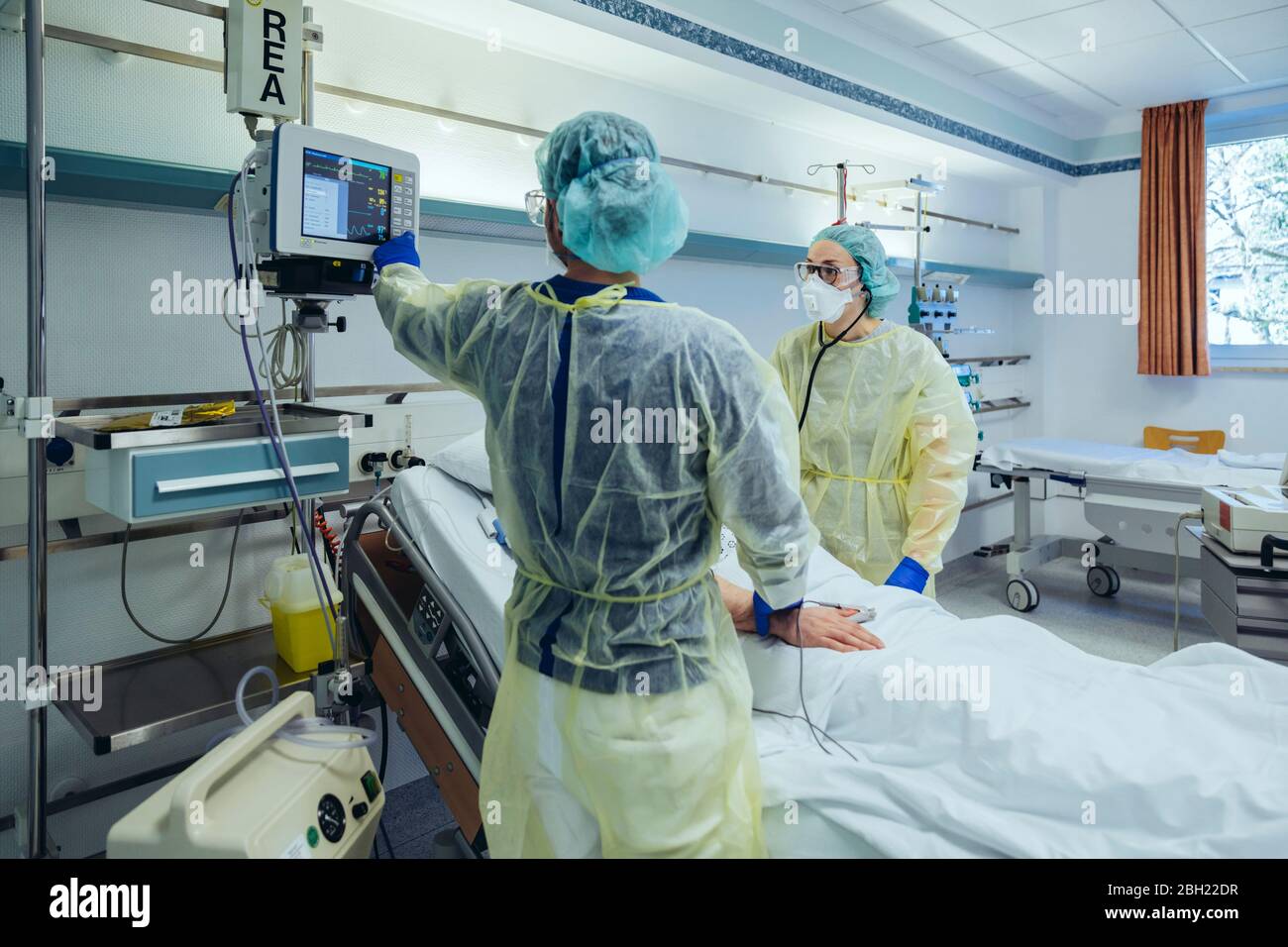 Doctors caring for patient in emergency care unit of a hospital looking ...