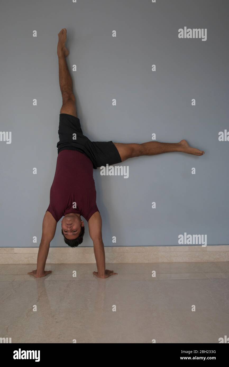Man doing handstand against the wall at home Stock Photo - Alamy