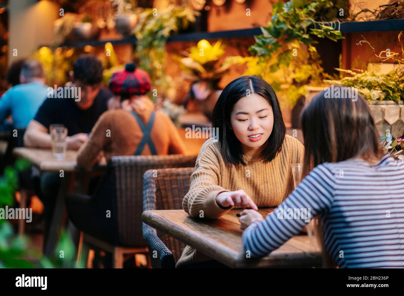 Friends having drinks in a restaurant, talking Stock Photo - Alamy