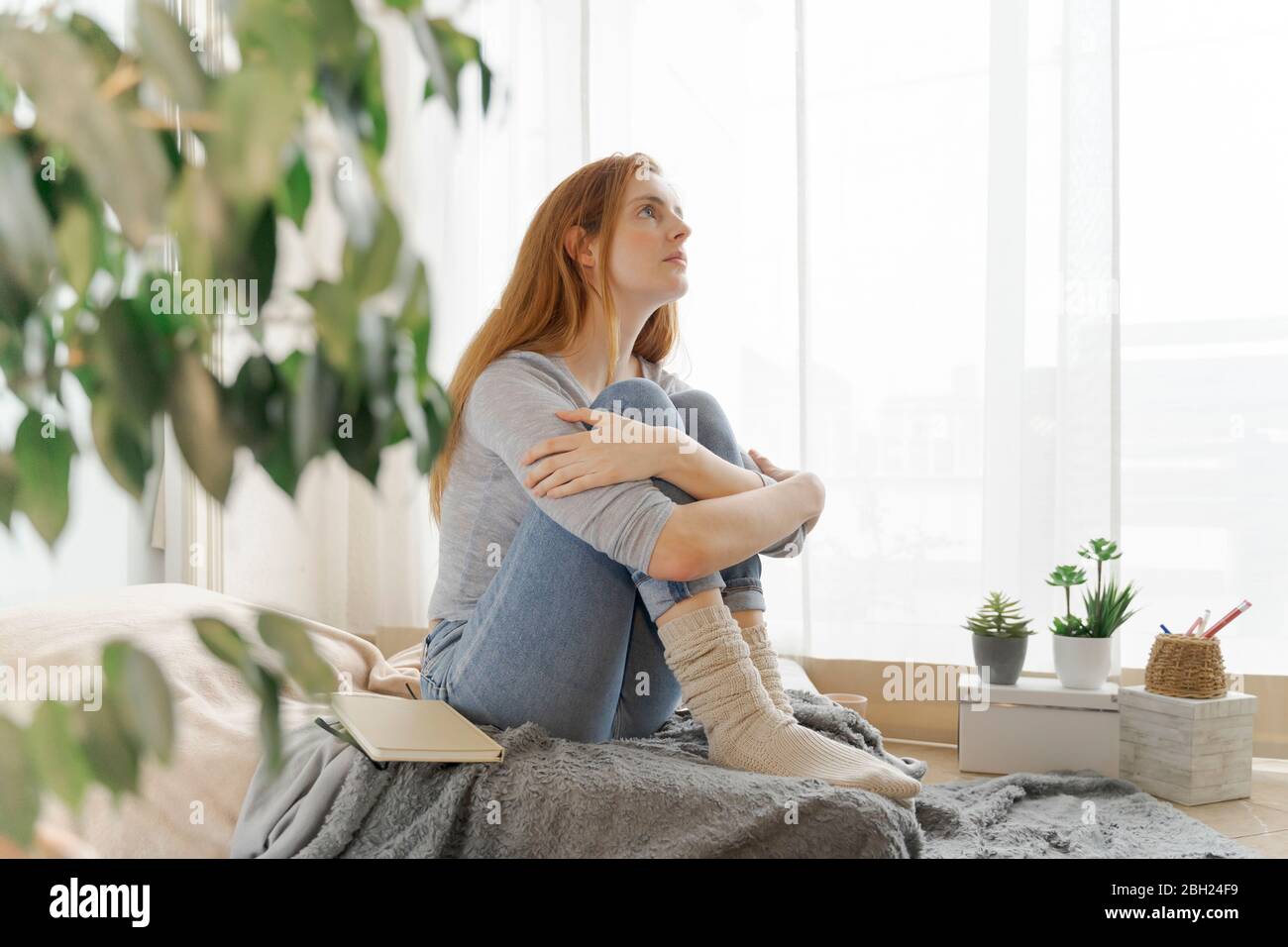 Serious young woman at home looking up Stock Photo - Alamy