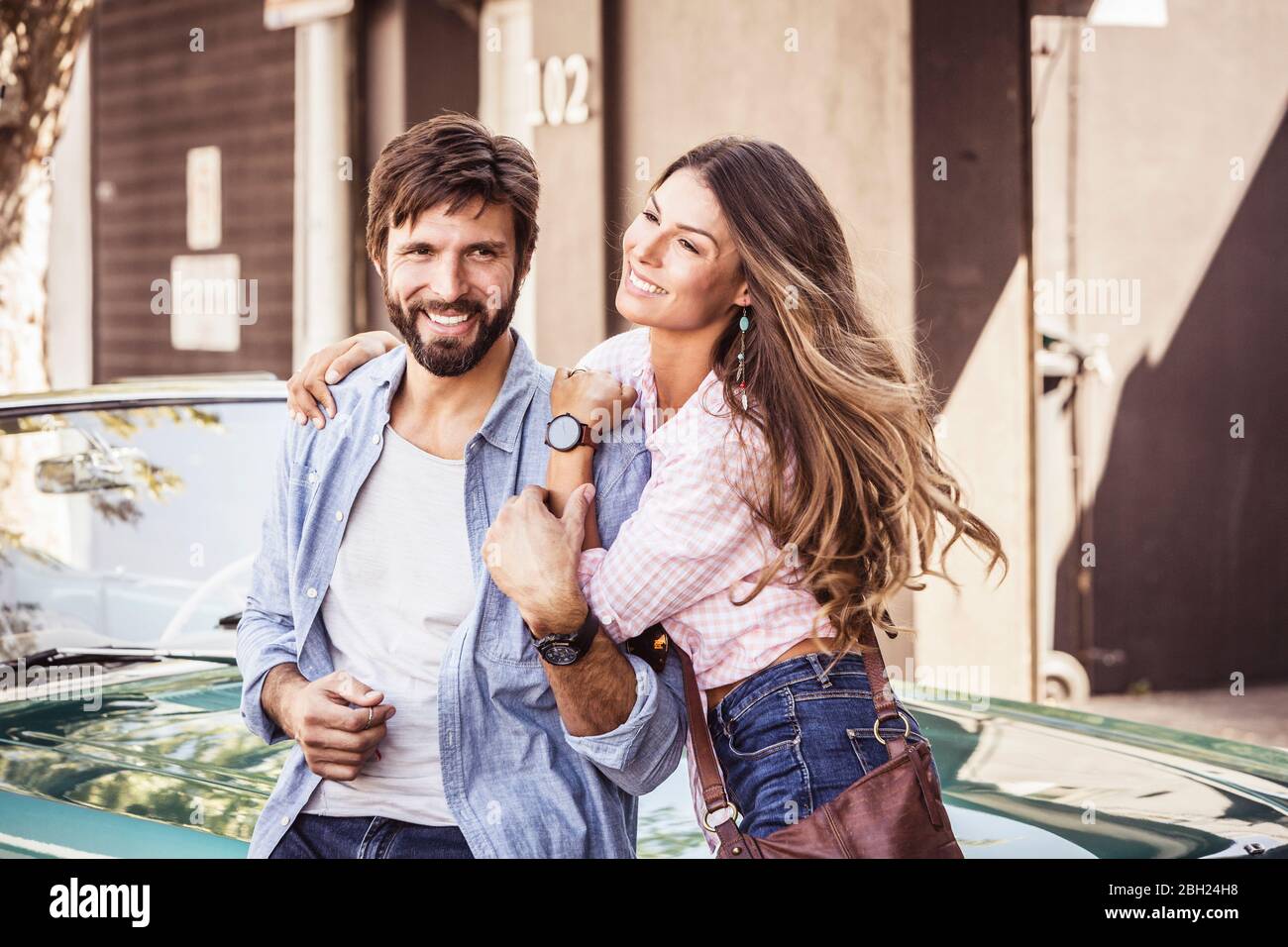 Happy couple at a convertible car outside house Stock Photo - Alamy