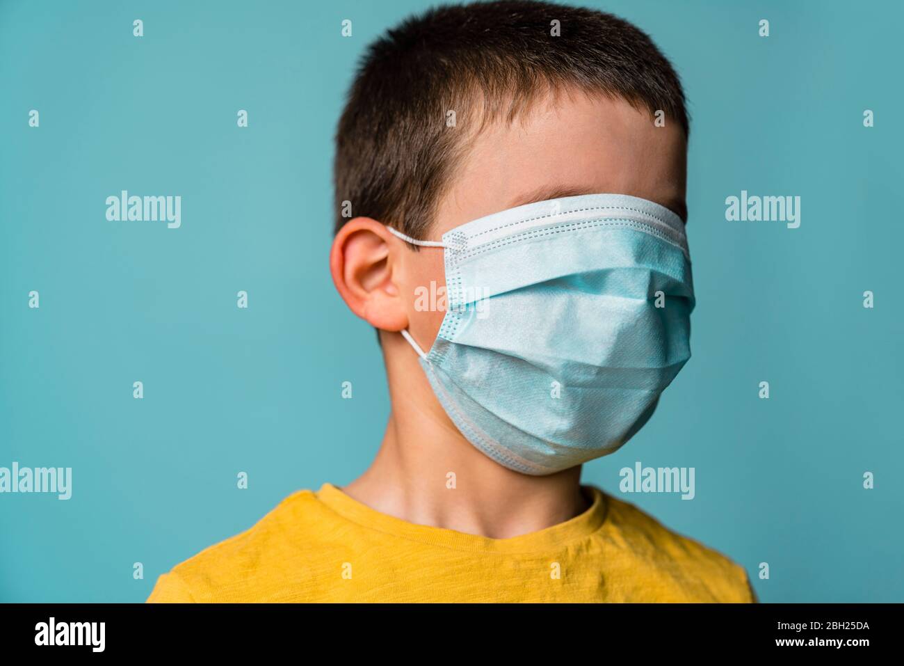 Portrait of boy covering his face with mask Stock Photo - Alamy