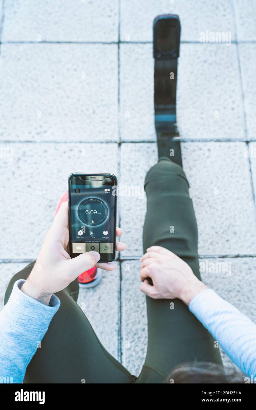 Disabled athlete with leg prosthesis having a break from exercising ...