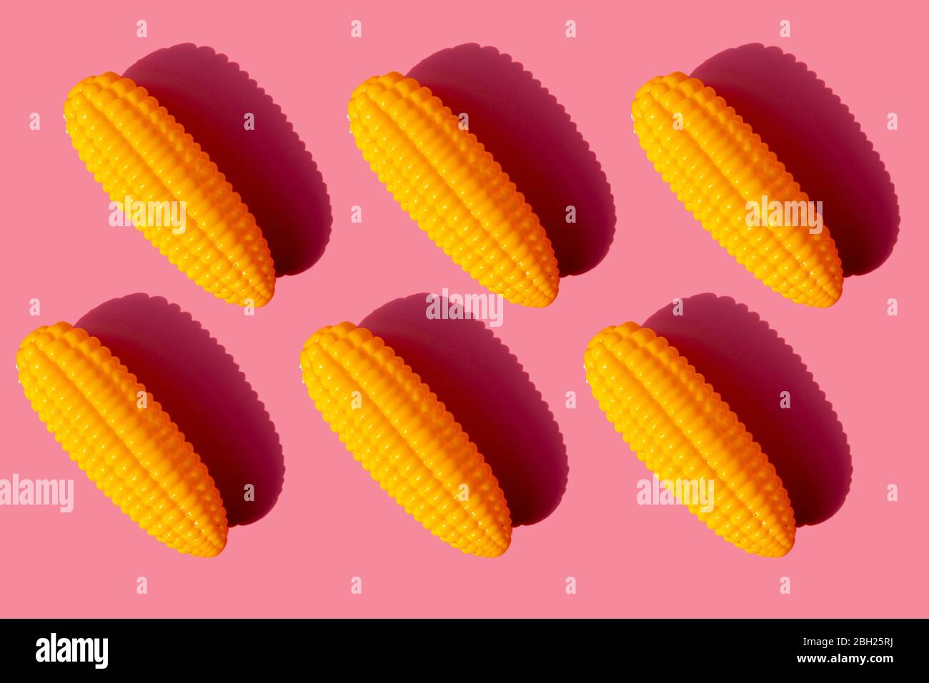 Studio shot of six plastic corn cobs against pink background Stock ...