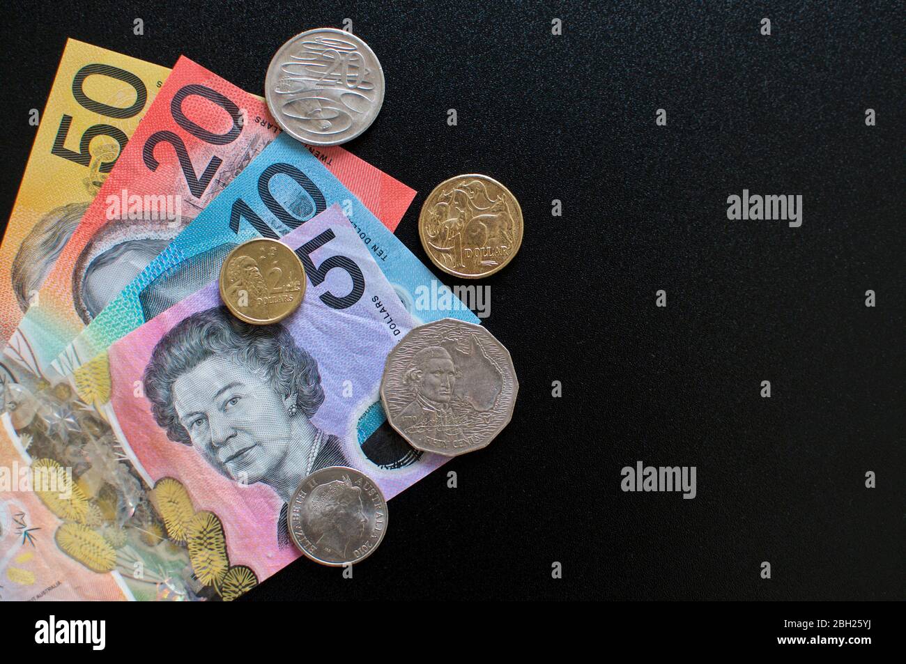 Close up picture of Australian banknotes and coins on a black ...