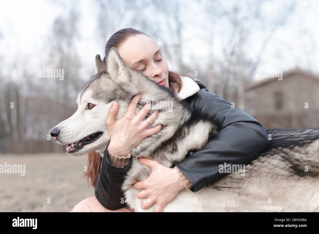 Happy woman cuddling her dog Stock Photo - Alamy