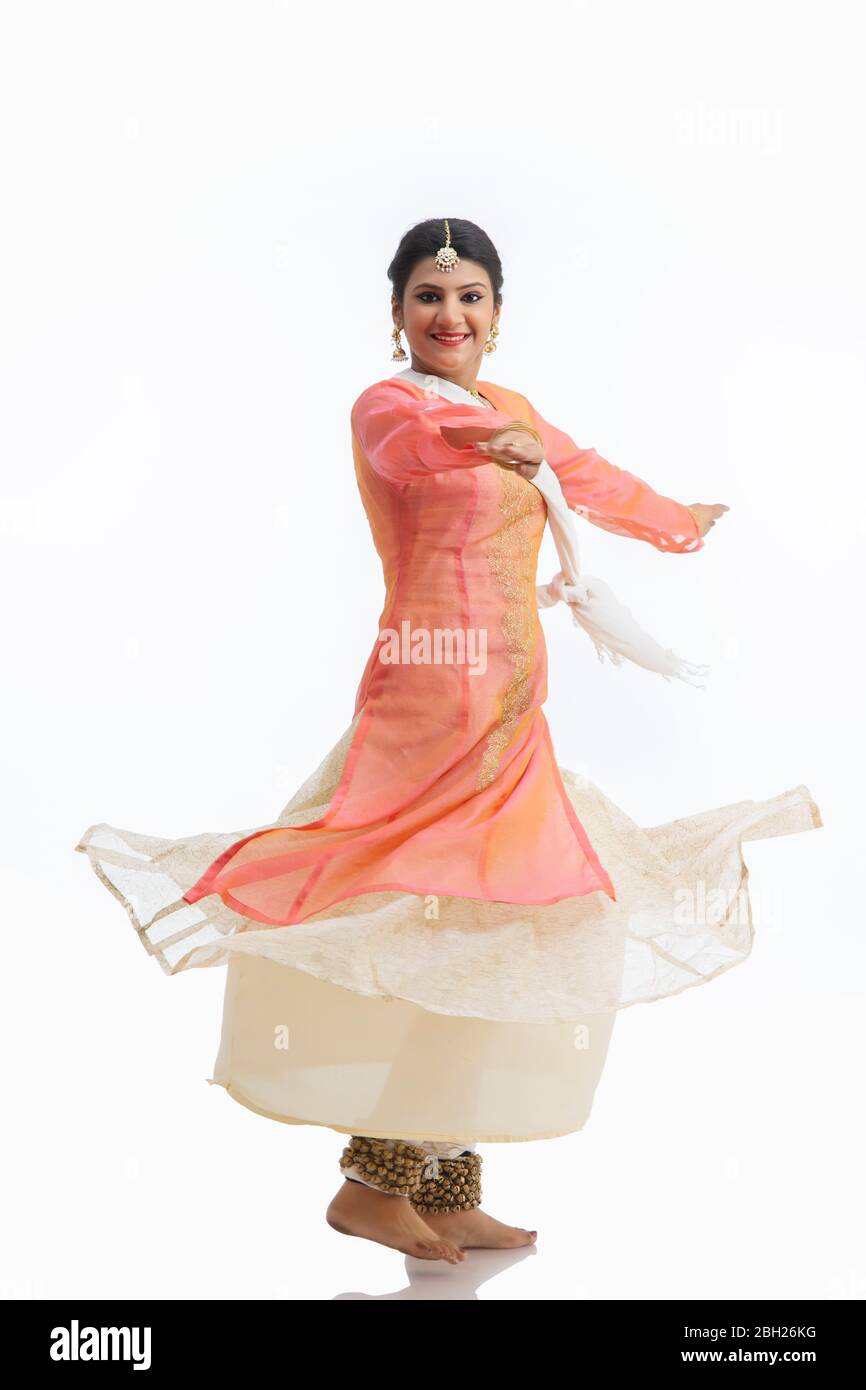 Beautiful kathak dancer circling in front of a white background and ...