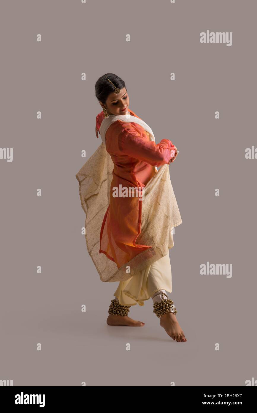 Beautiful kathak dancer performing gracefully over a plain background ...