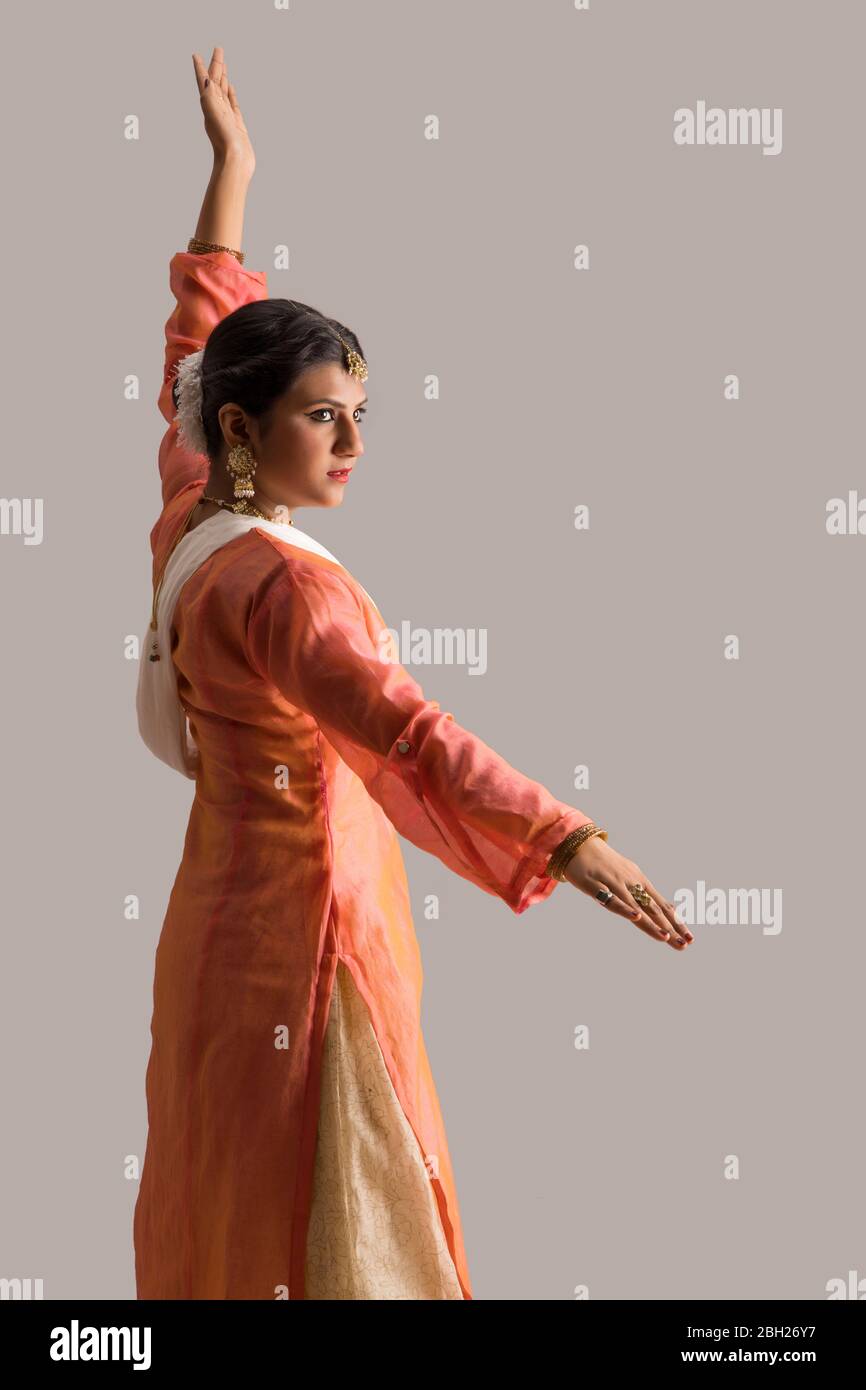 Beautiful kathak dancer performing through her expressions over a plain ...