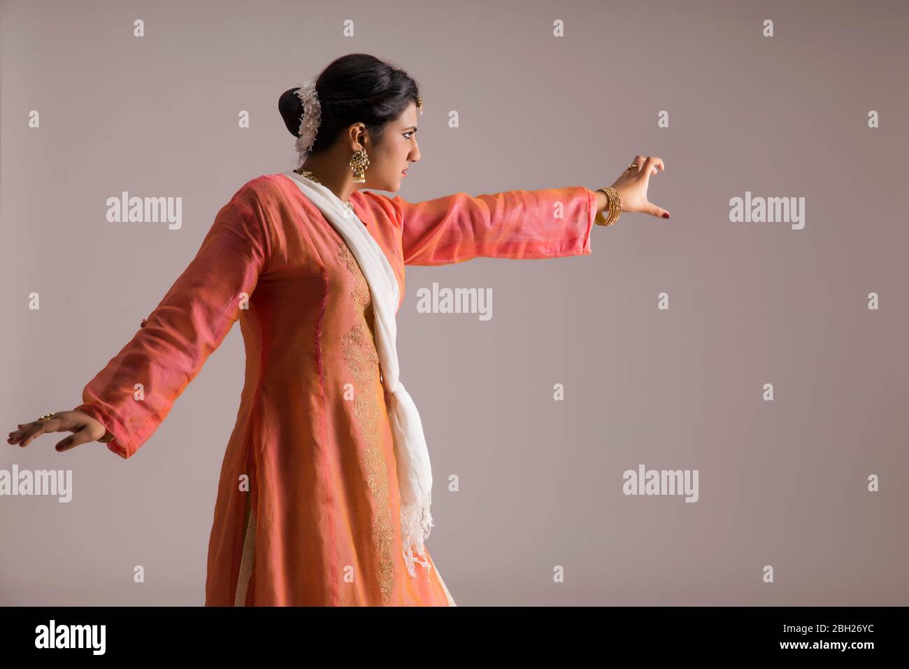 Beautiful kathak dancer performing through her expressions over a plain ...