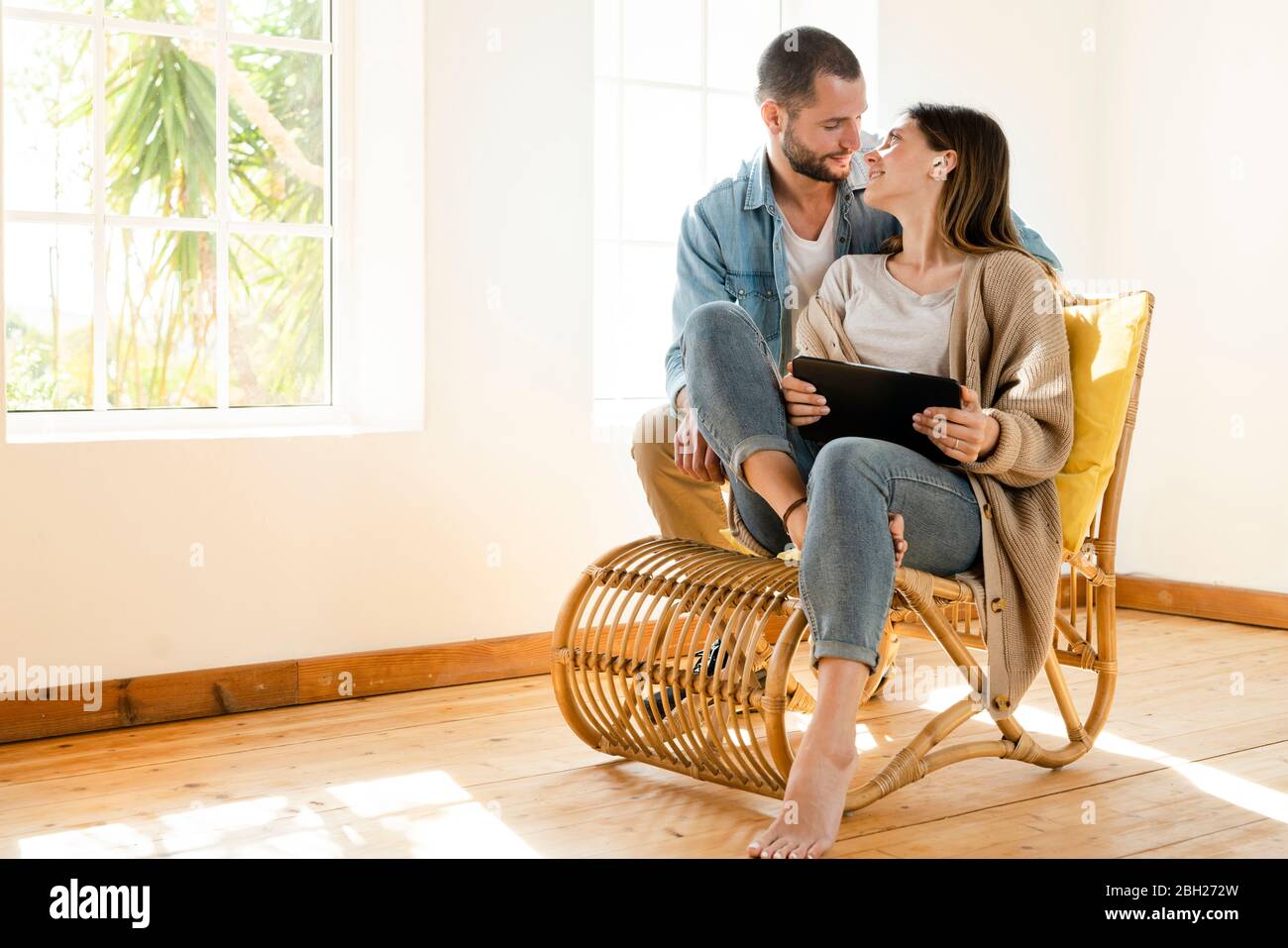 Affectionate happy couple at home about to kiss in front of window ...