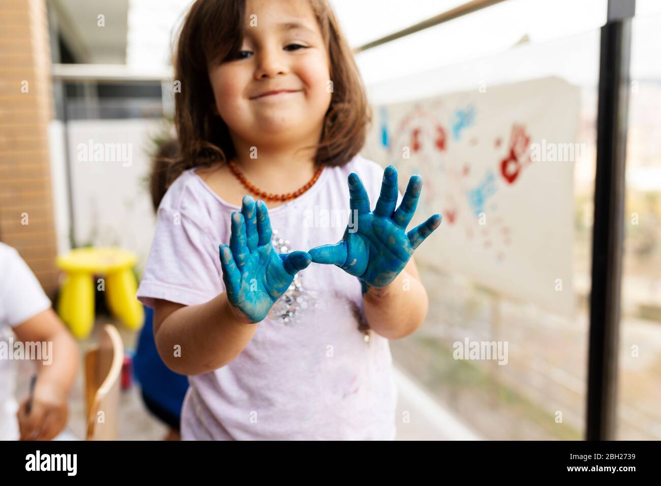 Little girl messing around with her painted hands Stock Photo - Alamy