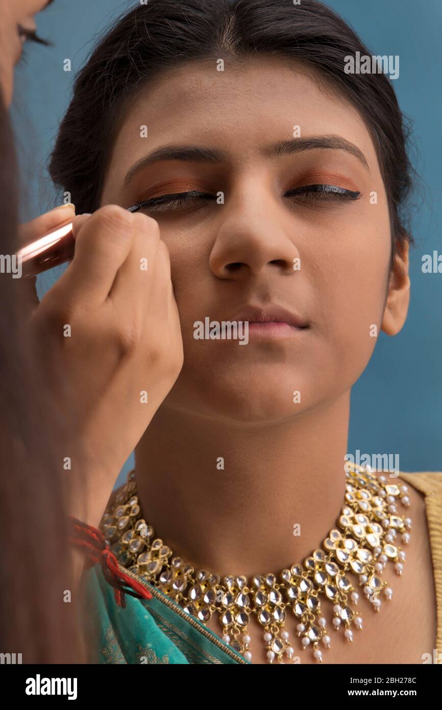 Makeup artist putting eyeliner on the kathak dancer’s eye Stock Photo ...