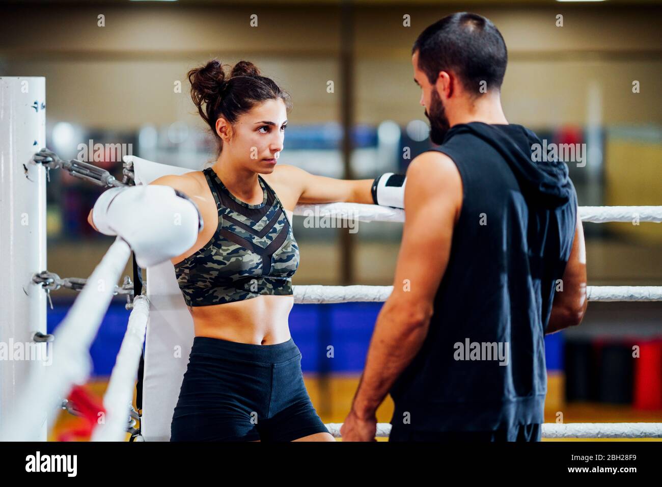 Trainer giving instructions in the corner to a female boxer before the ...
