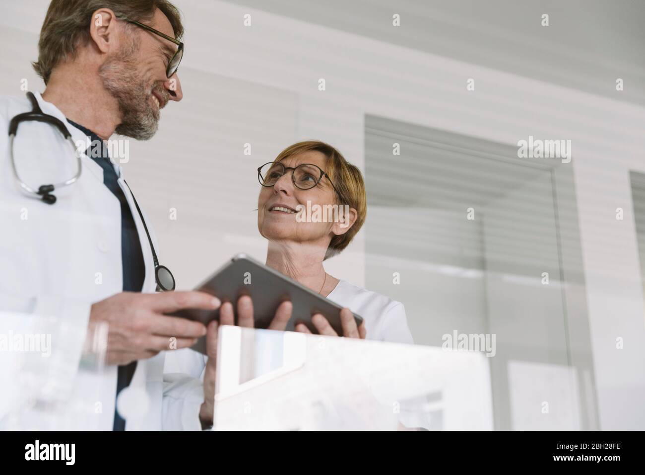 Doctor and assistant using tablet in medical practice Stock Photo - Alamy