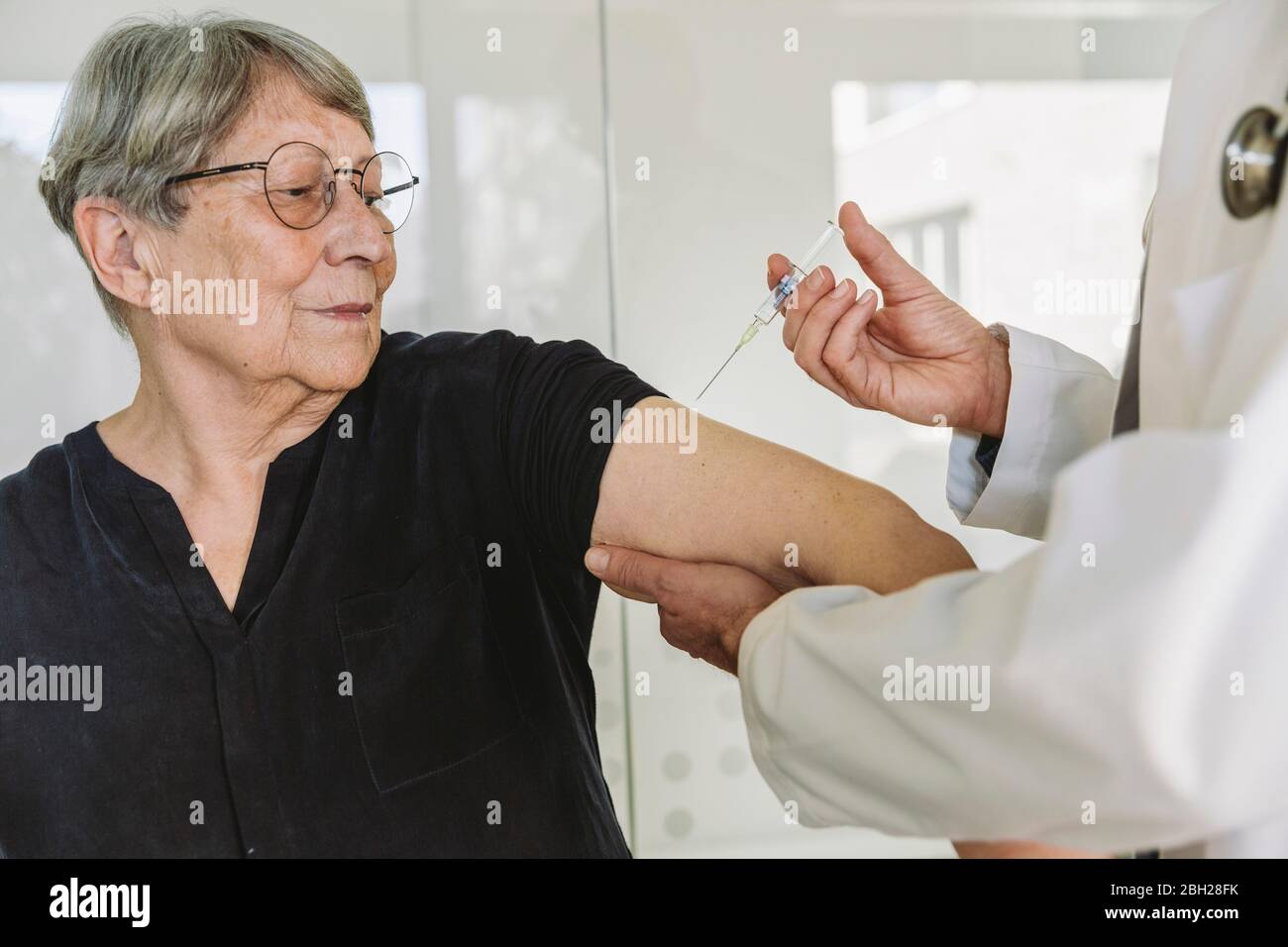 Doctor injecting vaccine into senior patient’s arm Stock Photo - Alamy