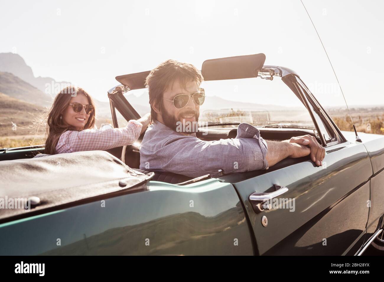 Couple in convertible car on a road trip Stock Photo - Alamy