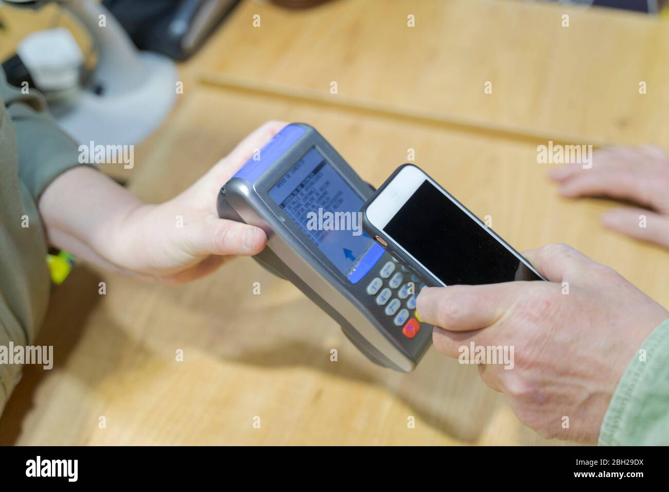 Customer paying contactless with smartphone in a shop Stock Photo - Alamy