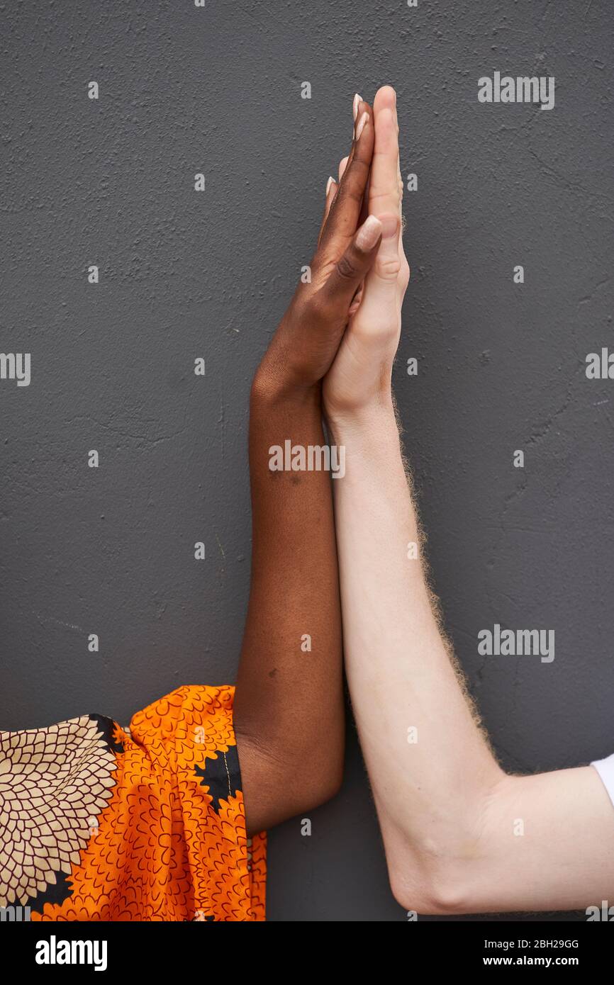 Couple joining hands in front of grey background Stock Photo - Alamy