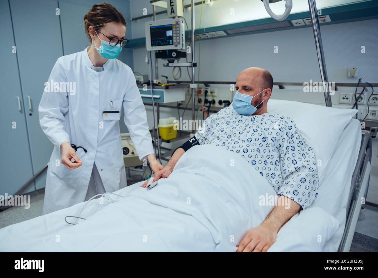 Doctor connecting patient to pulse tracer in hospital room Stock Photo ...