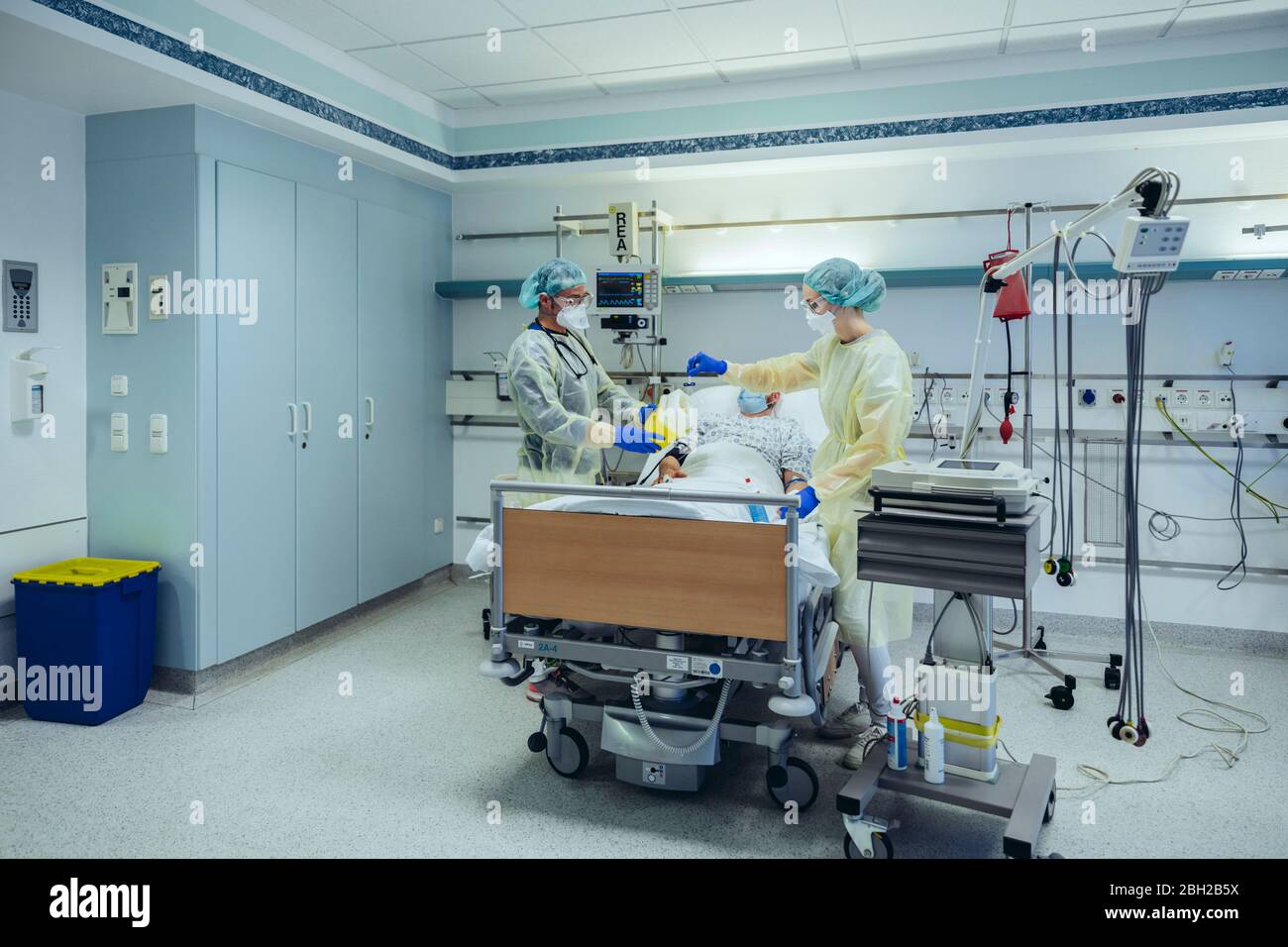 Doctors caring for patient in emergency care unit of a hospital taking ...