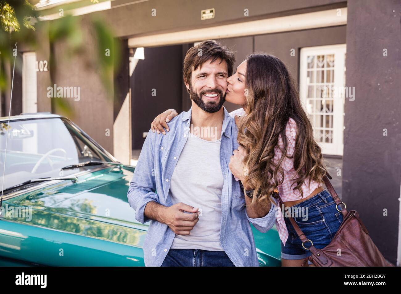 Happy couple at a convertible car outside house Stock Photo - Alamy