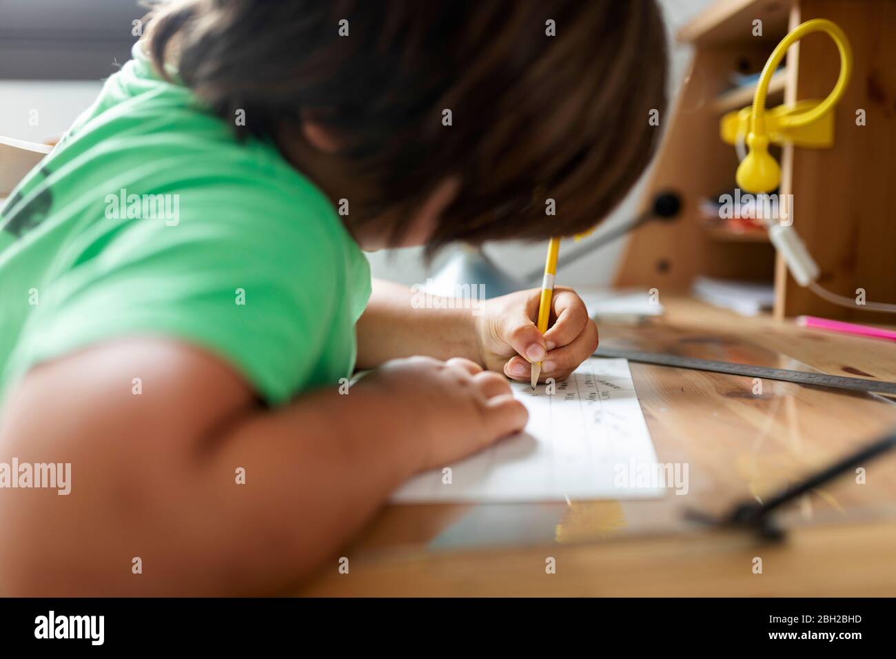 Boy doing his homework, sitting at desk Stock Photo - Alamy