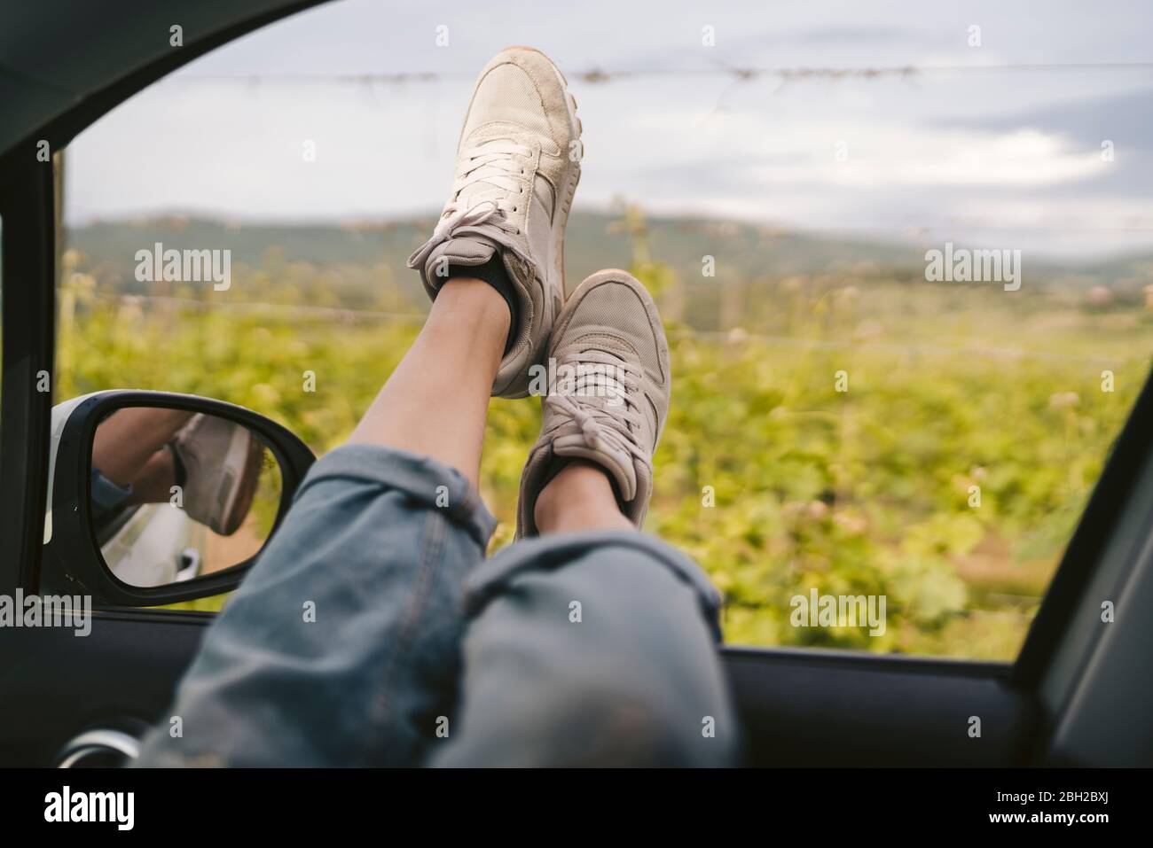 Woman's feet leaning out of car window Stock Photo - Alamy