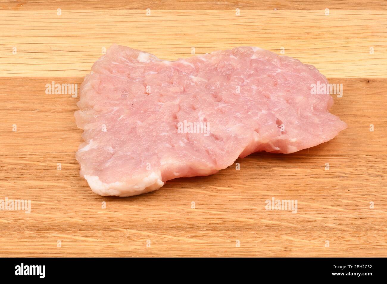 Fresh raw pork slice isolated on wood background. High resolution photo ...