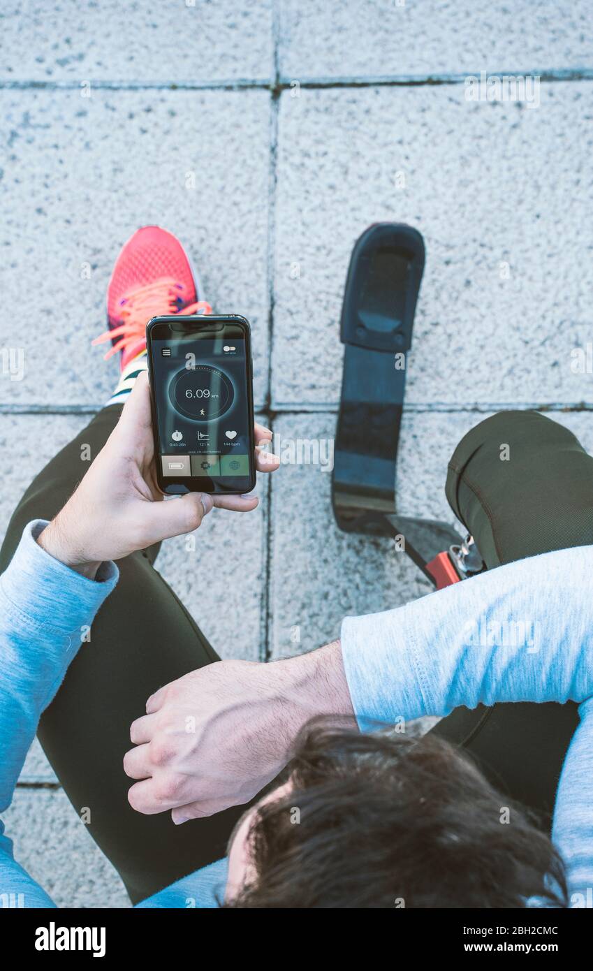 Disabled athlete with leg prosthesis having a break from exercising ...