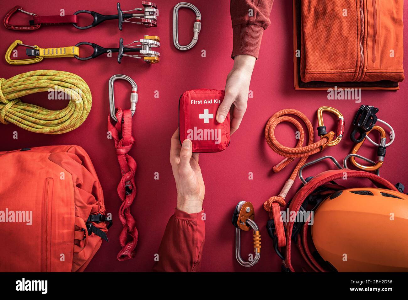 Overhead view of woman handing over first aid kit to man with climbing ...