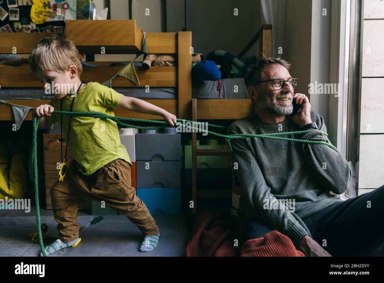 Little boy pulling his father speaking on phone Stock Photo - Alamy