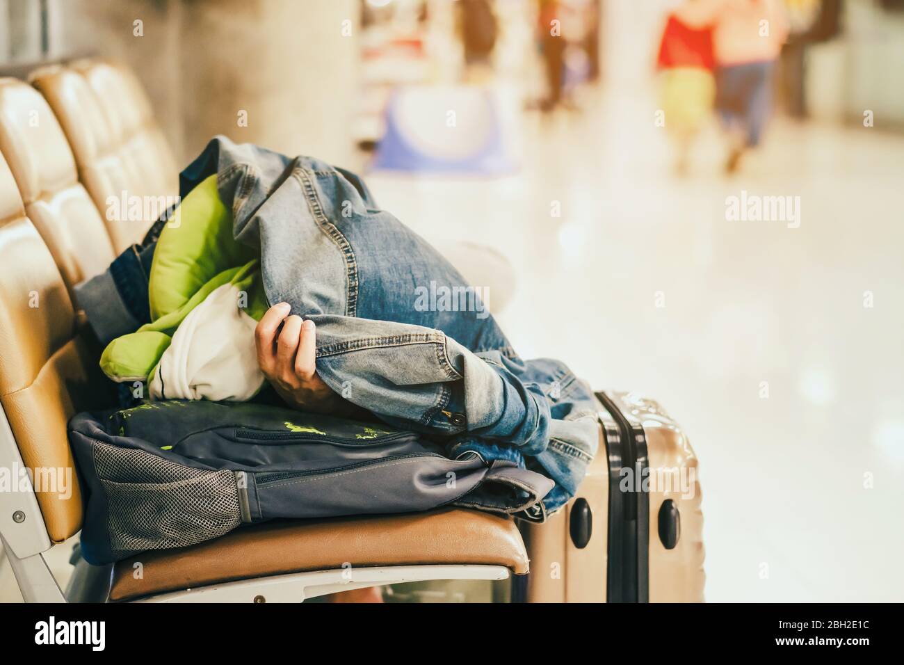 Tired passenger napping on a benches while waiting for boarding in the ...