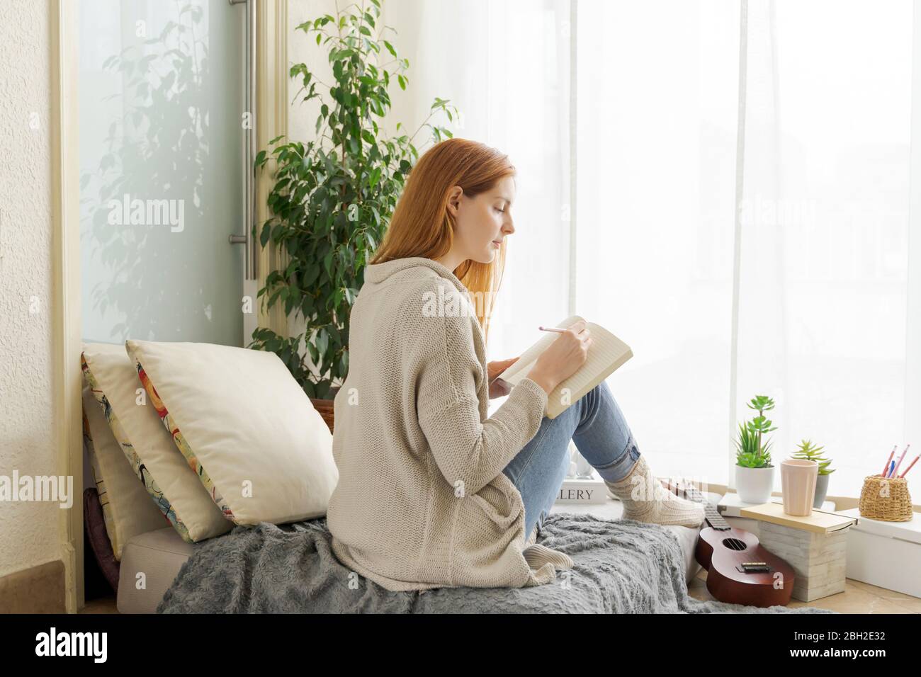 Young woman taking notes at home Stock Photo - Alamy