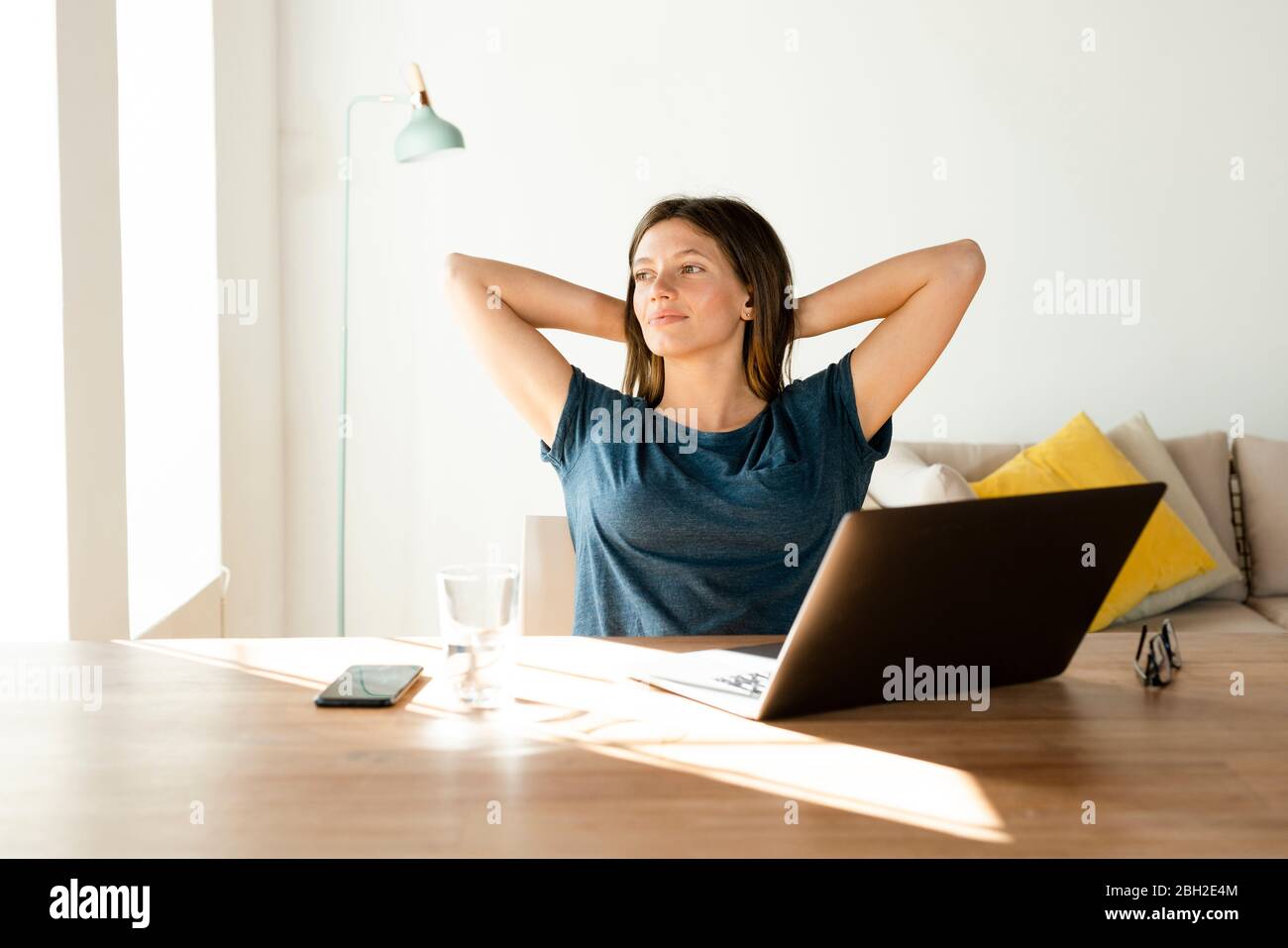Content young woman at home having a break from working at laptop in ...