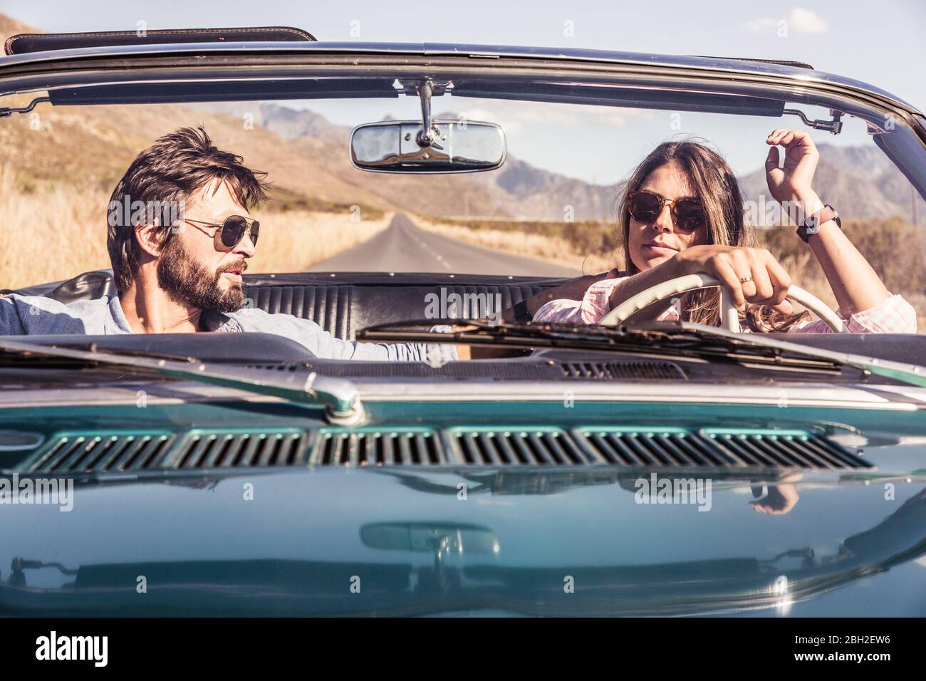 Couple in convertible car on a road trip Stock Photo - Alamy